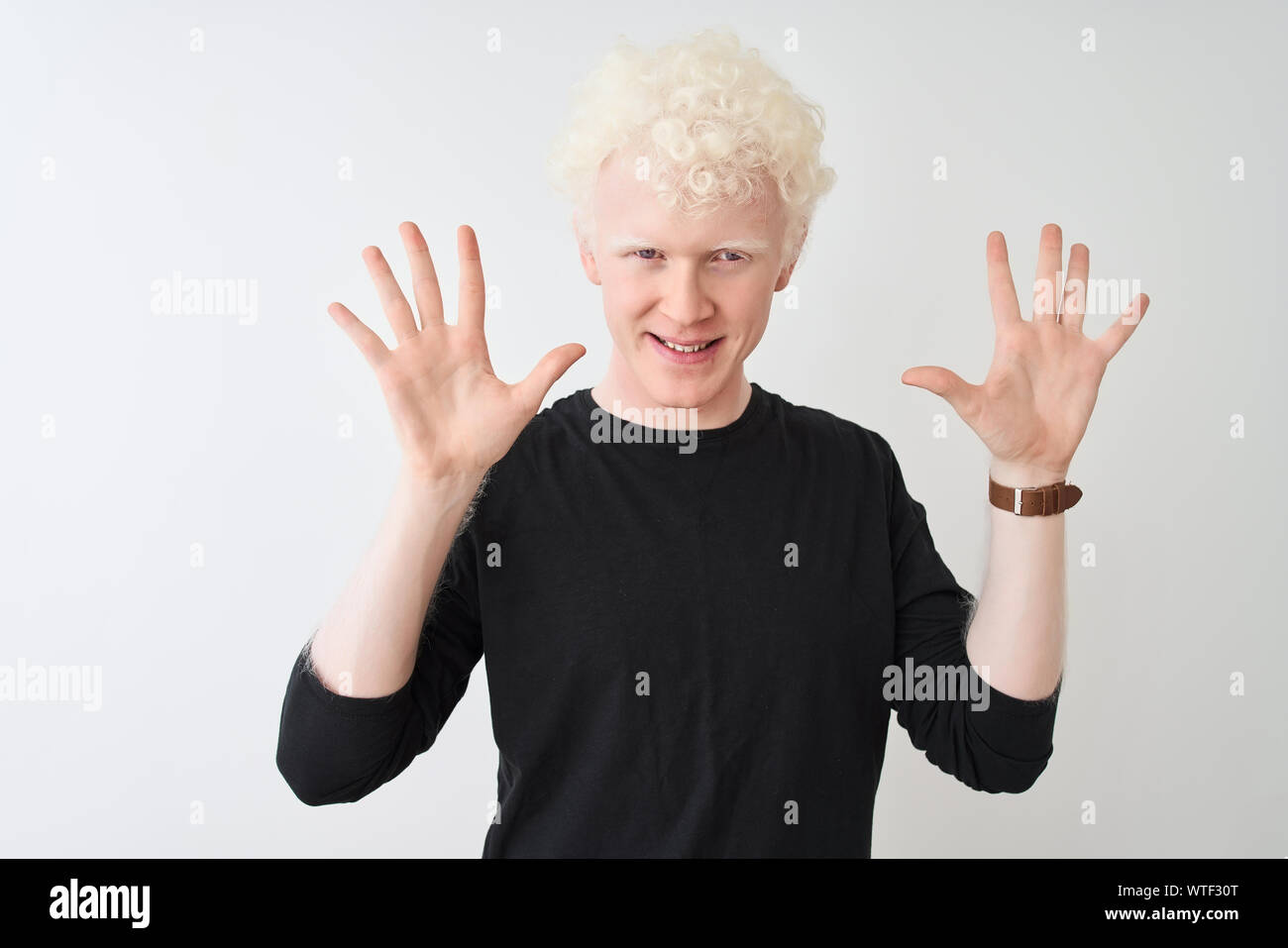 Young albino blond man wearing black t-shirt standing over isolated ...