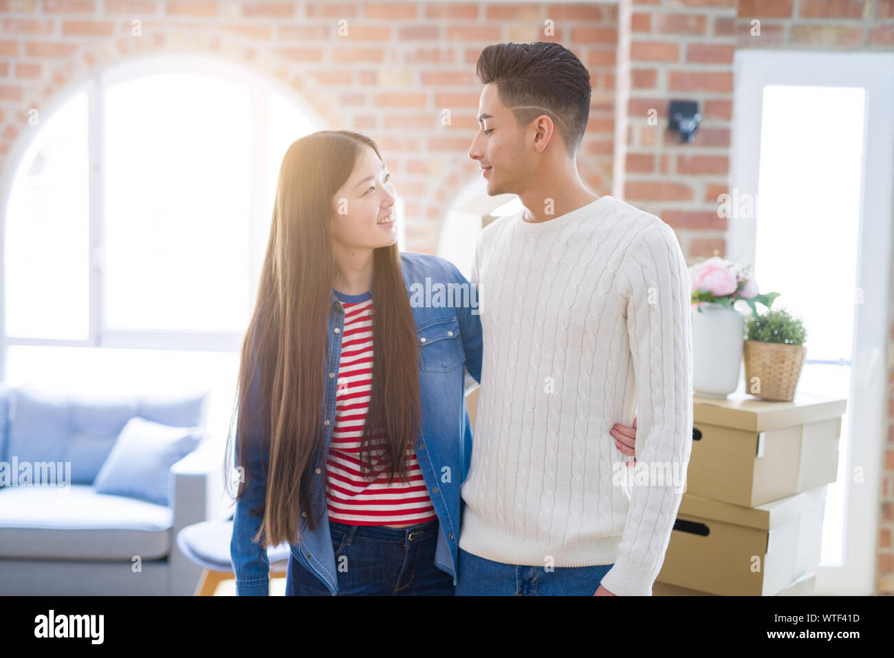 Beautiful young asian couple looking happy and smiling excited moving ...