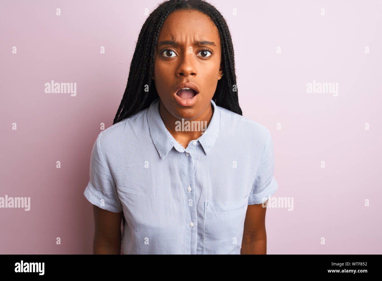 Young African American Woman Wearing Striped Shirt Standing Over