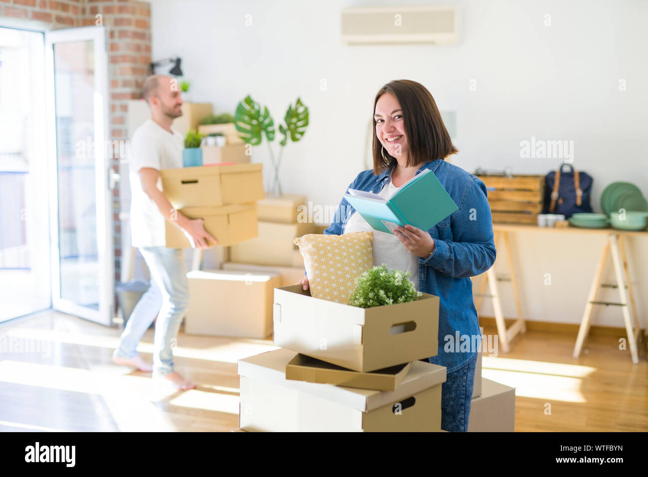 Young couple moving to new apartment, beautiful woman moving cardboard ...