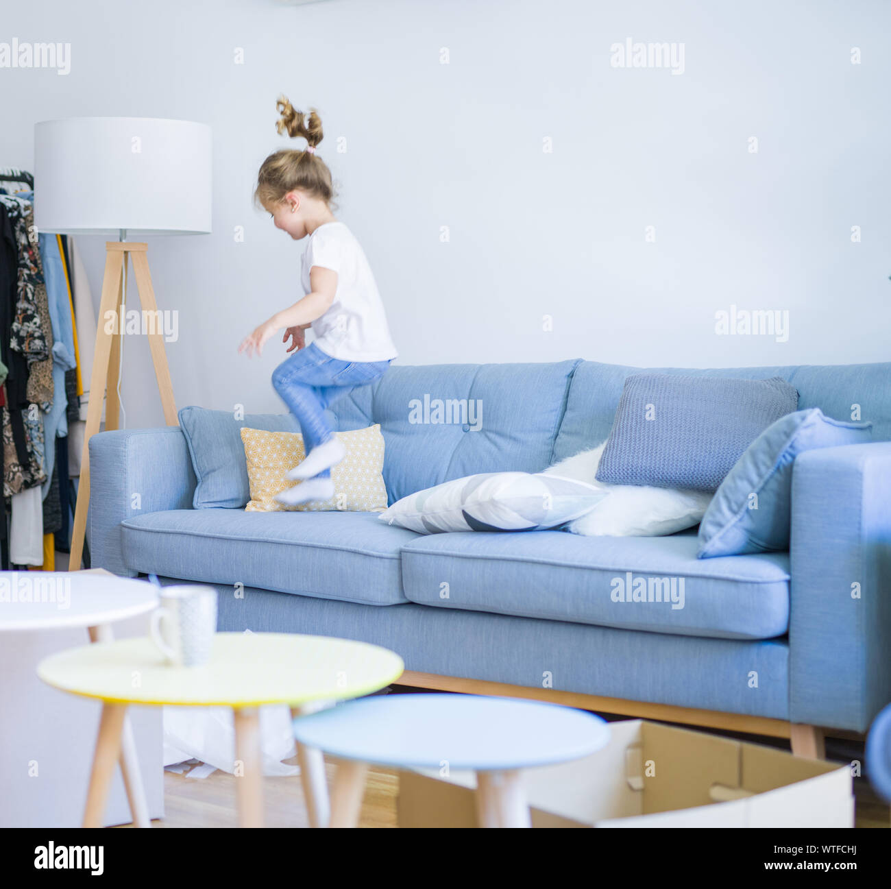 Beautiful toddler child girl jumping on the sofa Stock Photo - Alamy