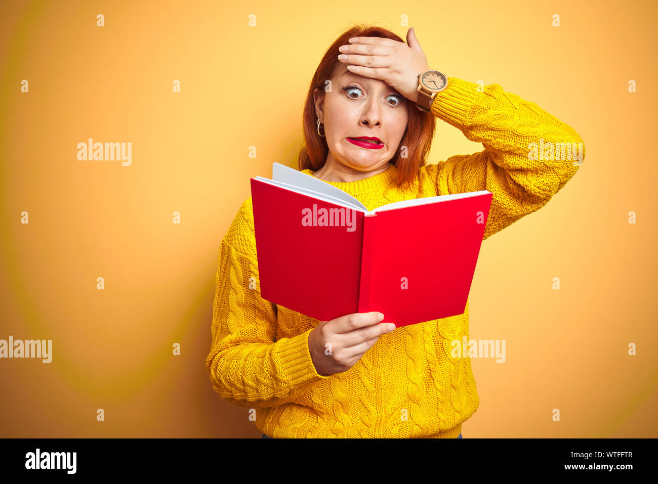 Young redhead teacher woman reading red book over yellow isolated ...