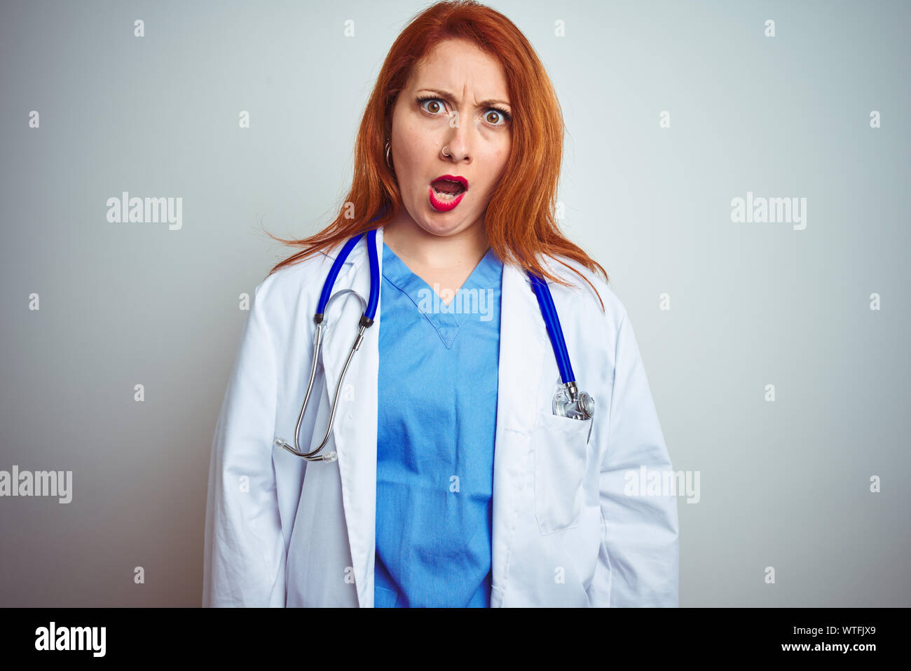 Young redhead doctor woman using stethoscope over white isolated ...