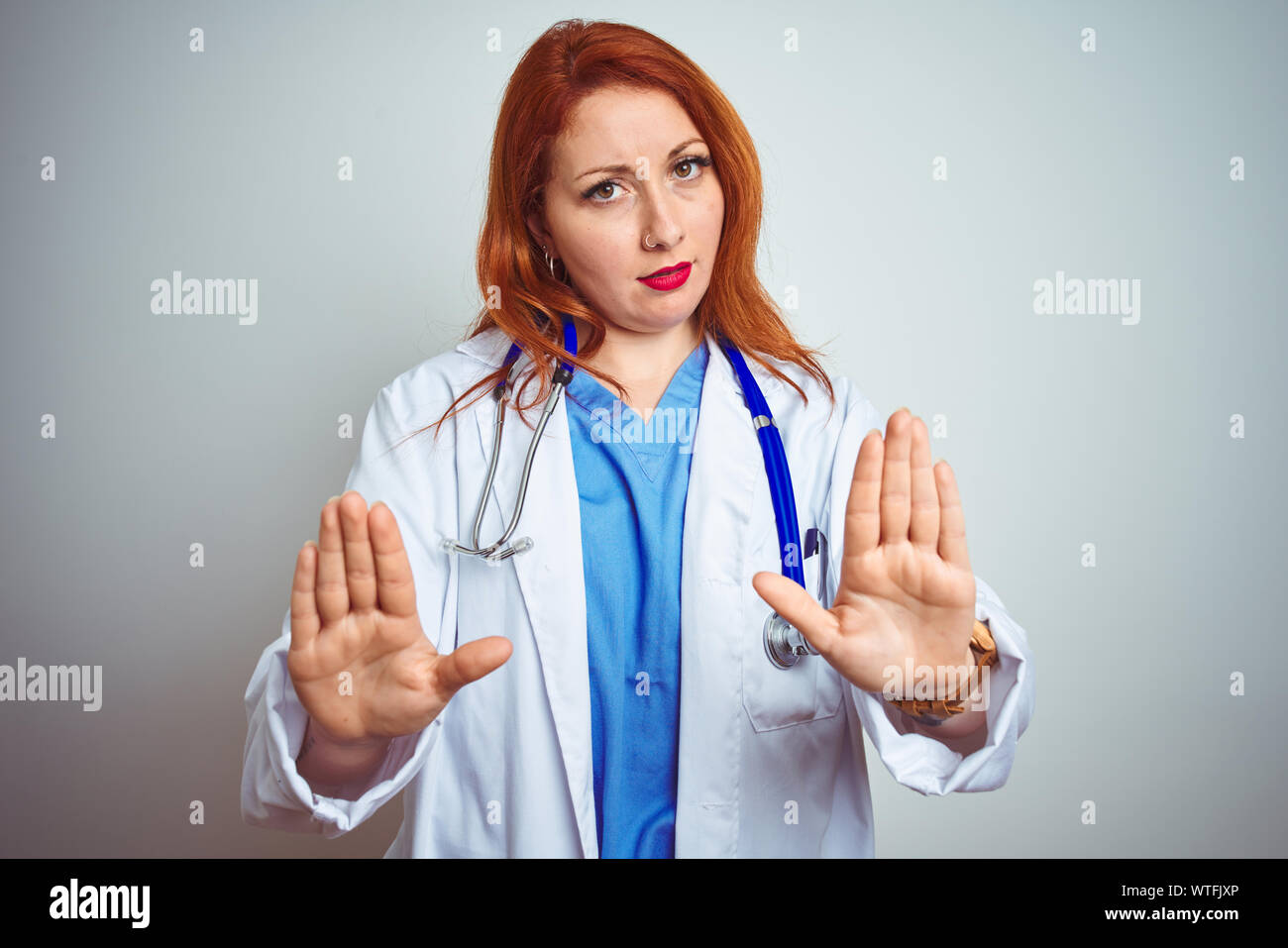 Young redhead doctor woman using stethoscope over white isolated ...