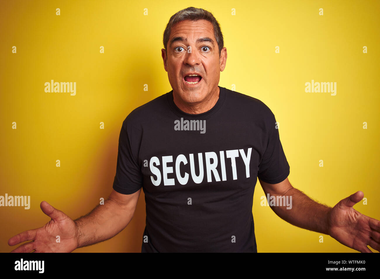 Middle age safeguard man wearing security uniform over isolated yellow ...