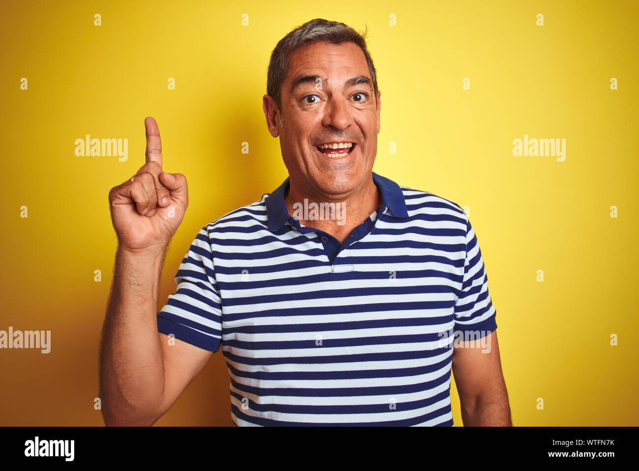 Handsome middle age man wearing striped polo standing over isolated ...