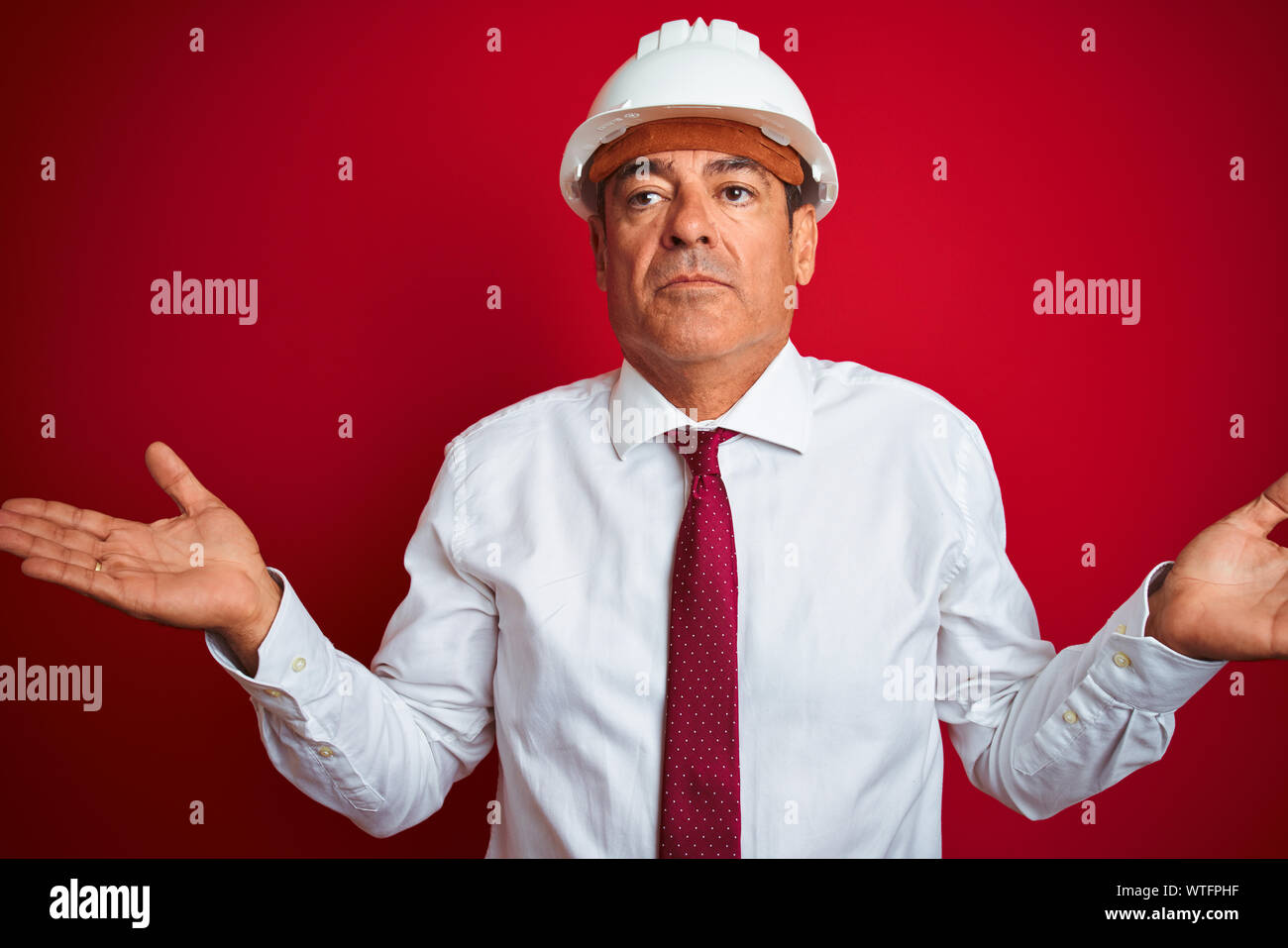 Handsome middle age engineer man wearing security helmet over isolated ...