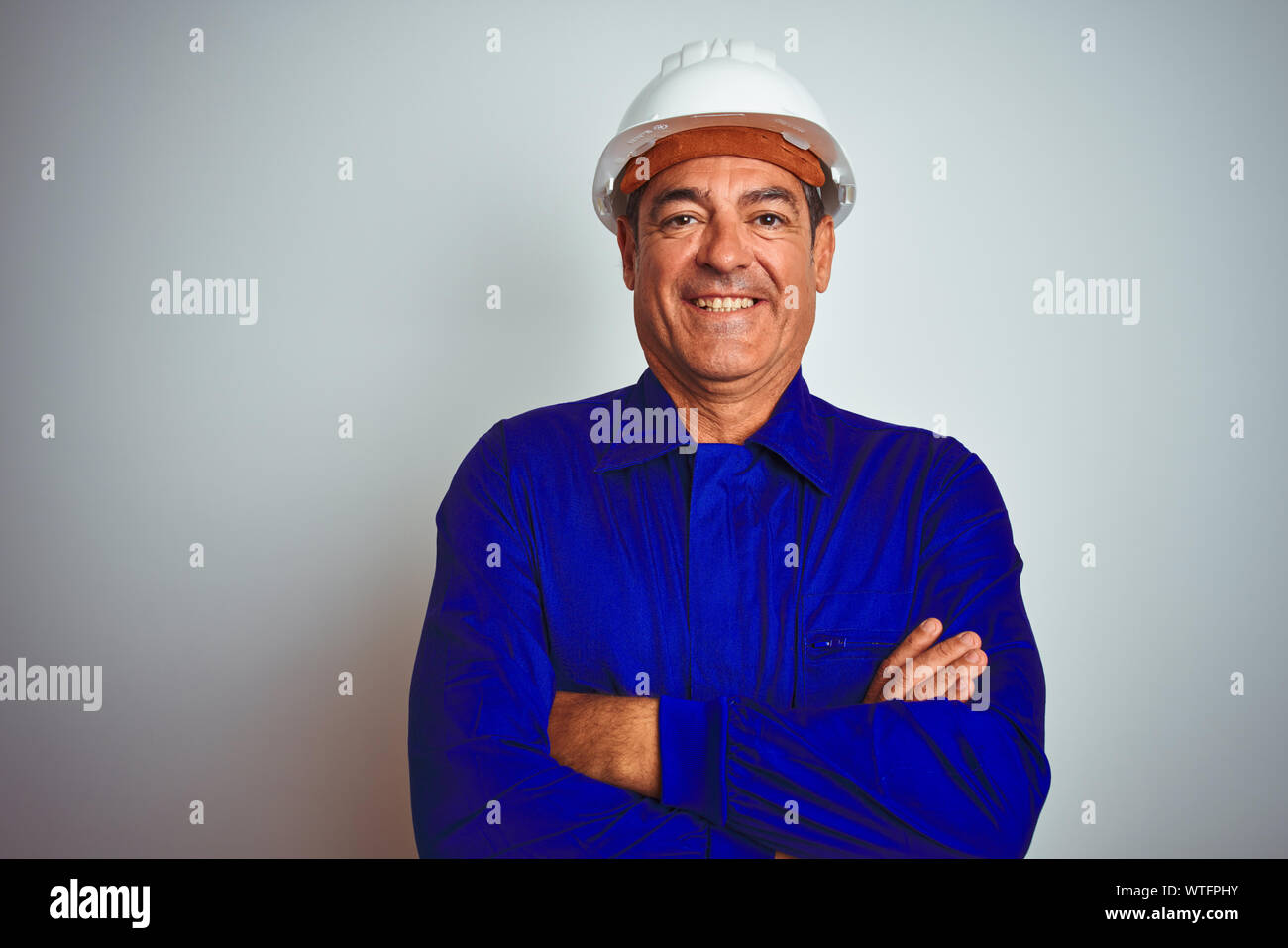 Handsome middle age worker man wearing uniform and helmet over isolated ...
