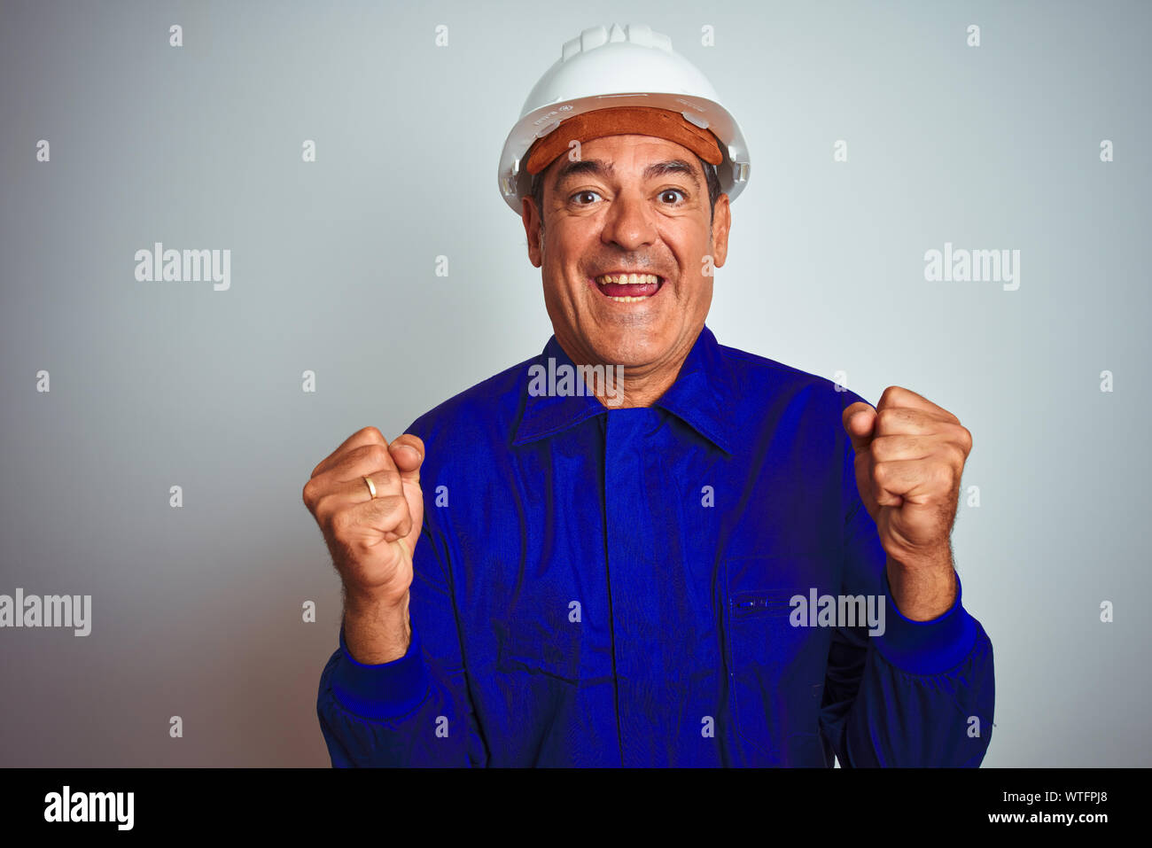 Handsome middle age worker man wearing uniform and helmet over isolated ...