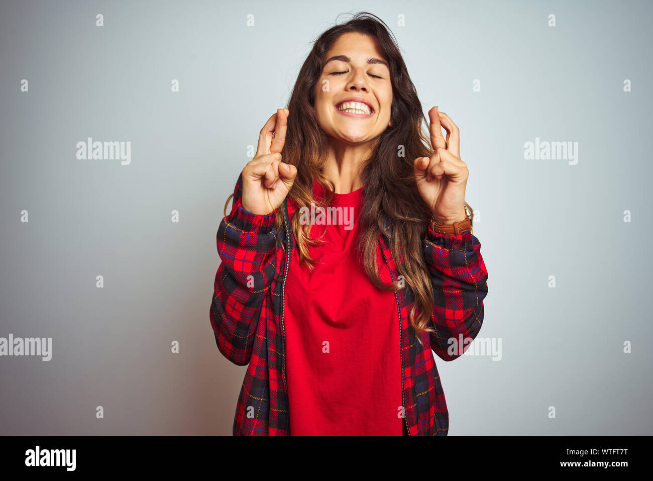 Young beautiful woman wearing red t-shirt and jacket standing over ...