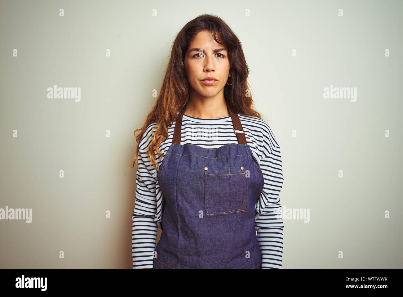 Young beautiful chef woman wearing apron cooking over white isolated ...