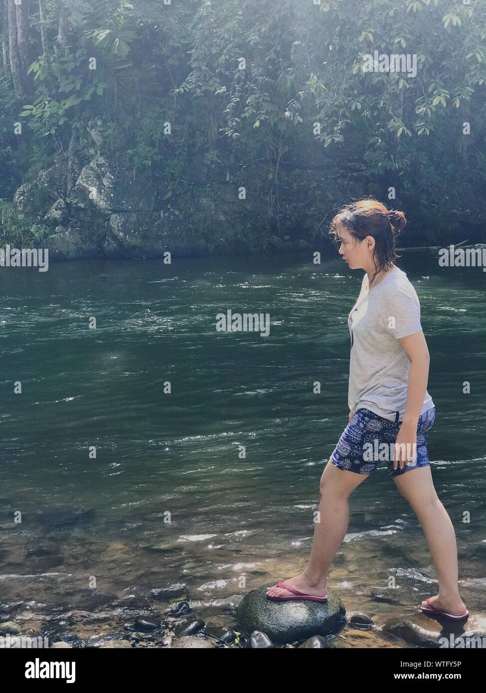 Woman walking on river rocks hi-res stock photography and images - Alamy