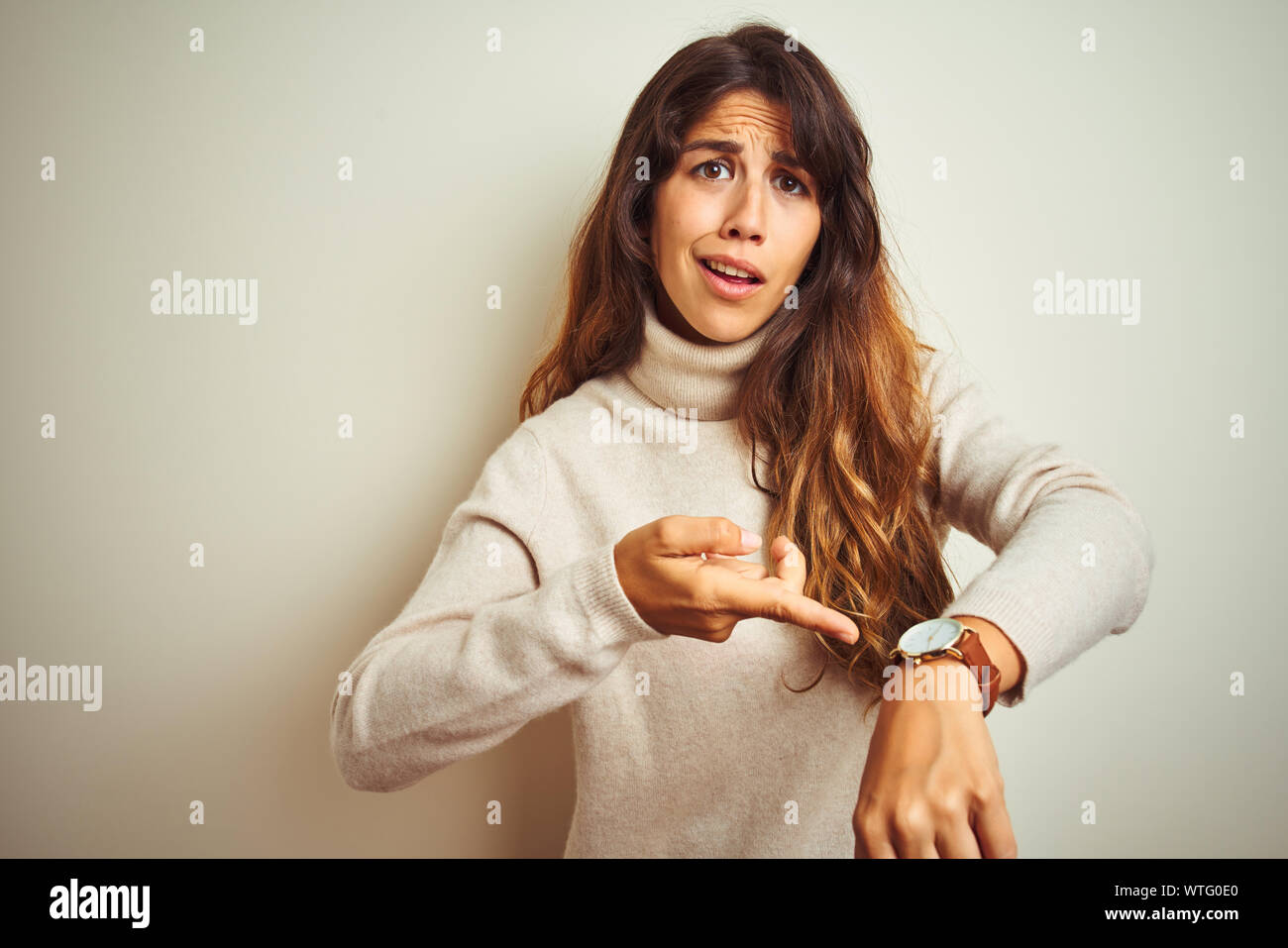 Young beautiful woman wearing winter sweater standing over white ...