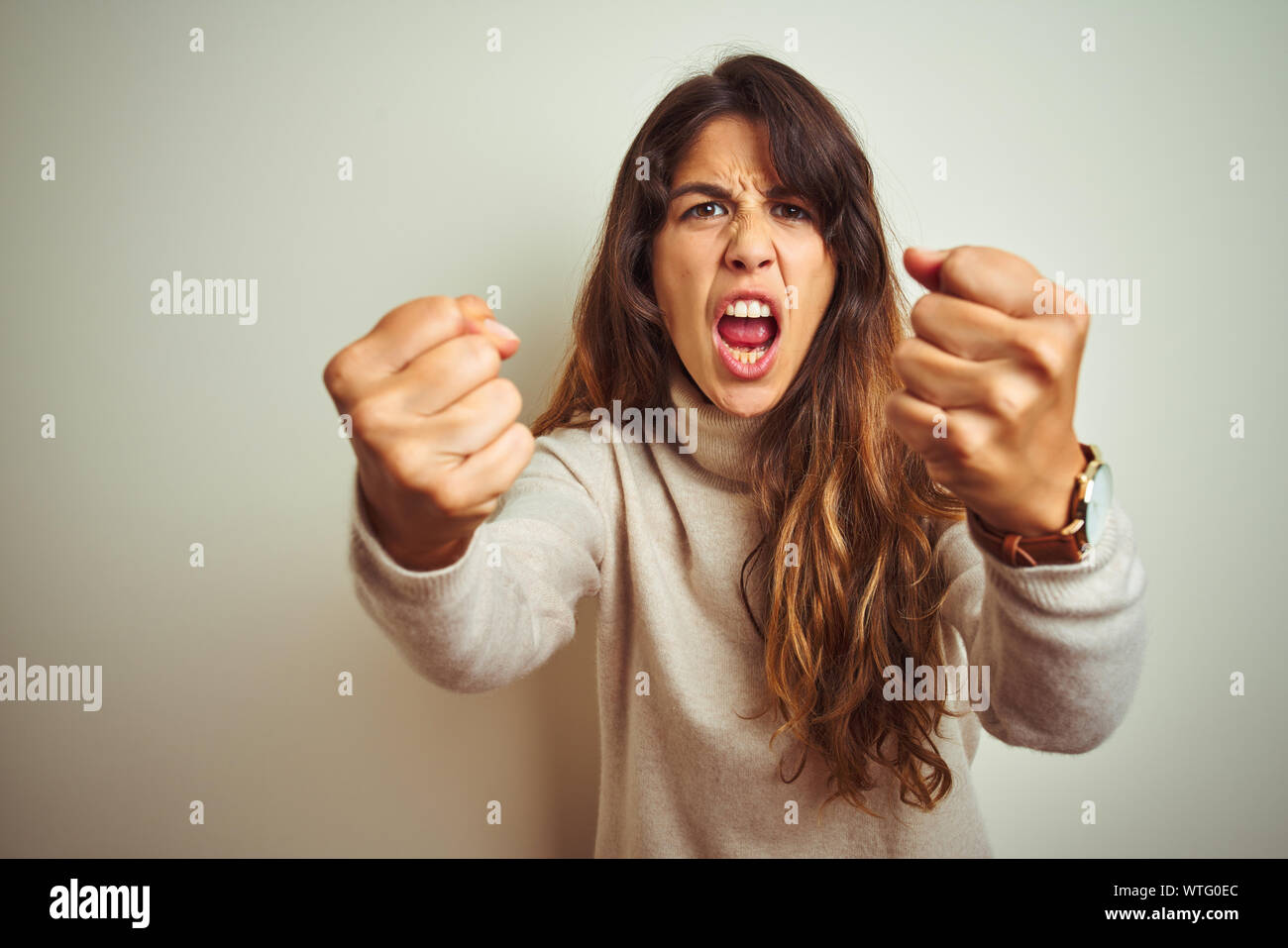 Young beautiful woman wearing winter sweater standing over white ...