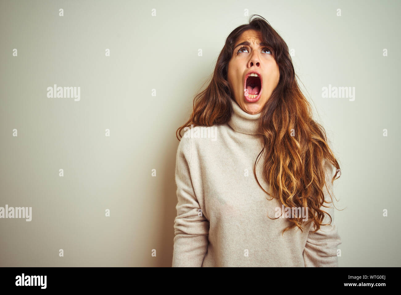 Young beautiful woman wearing winter sweater standing over white ...