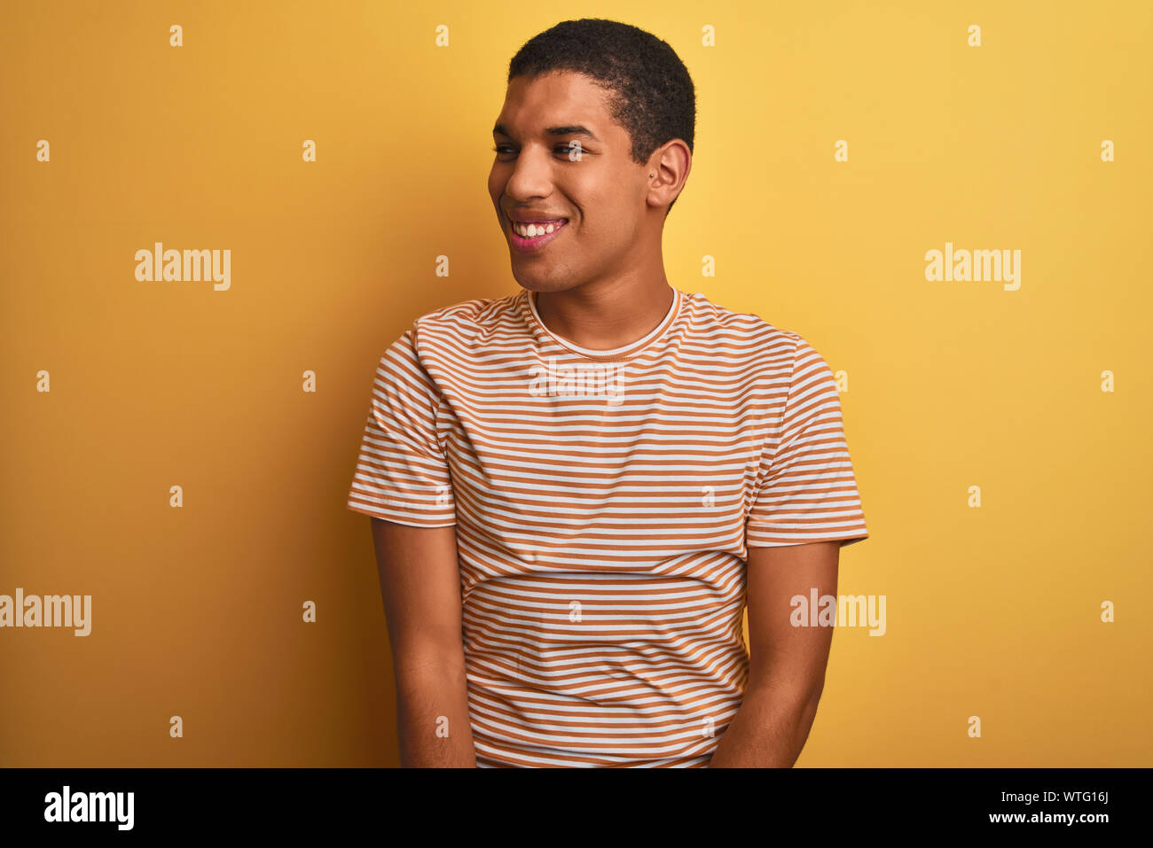Young handsome arab man wearing striped t-shirt standing over isolated ...