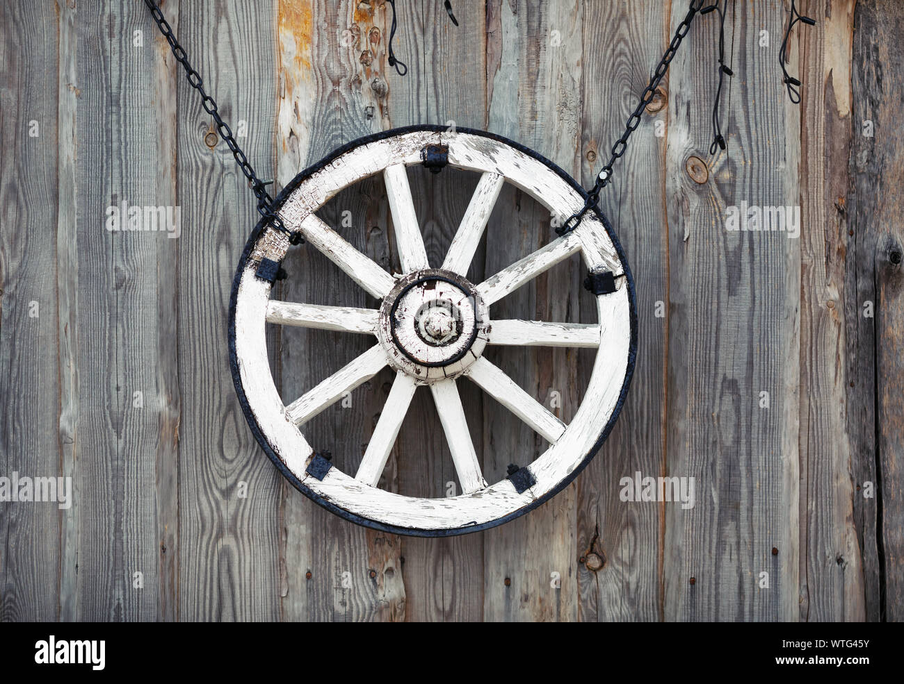 Old cart wheel hanging on vintage wooden wall Stock Photo - Alamy
