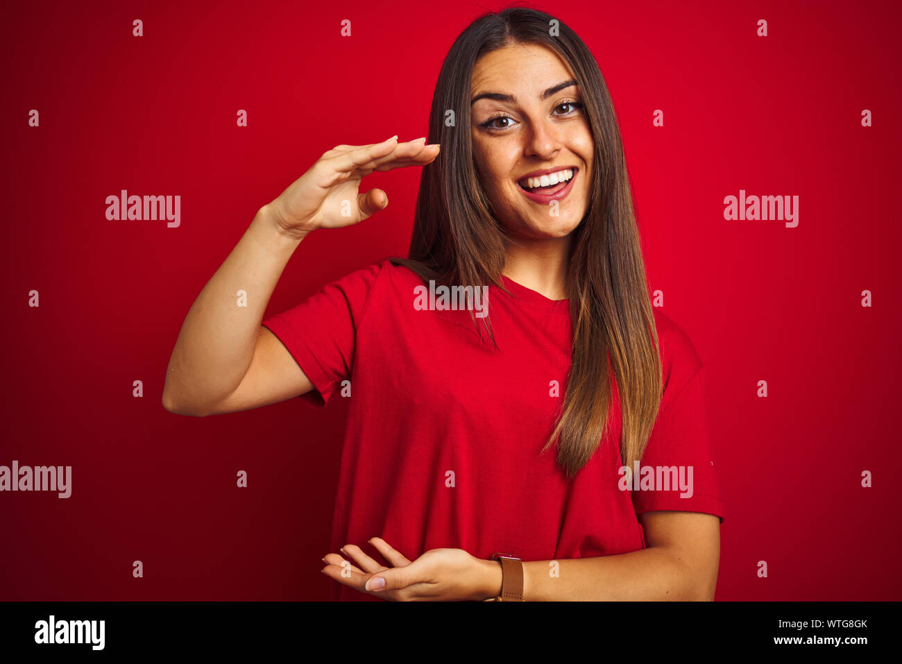Young beautiful woman wearing t-shirt standing over isolated red ...