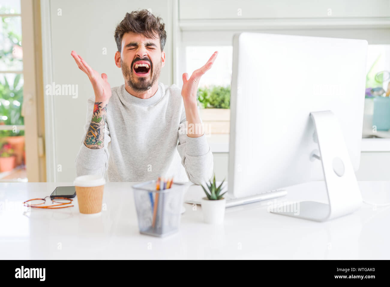 Young man working using computer celebrating mad and crazy for success ...
