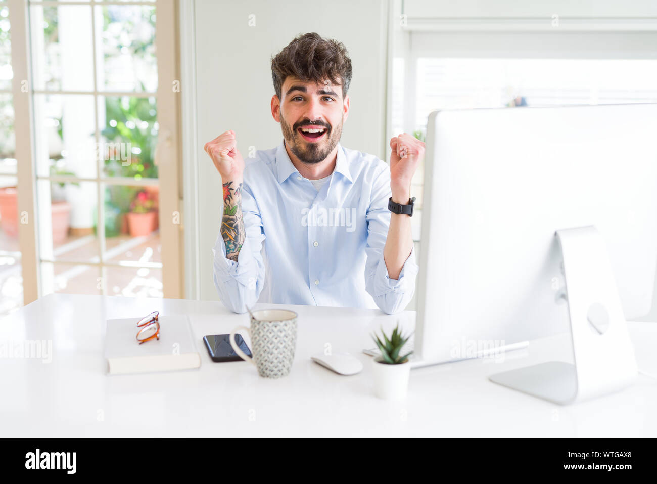 Young business man working using computer celebrating surprised and ...