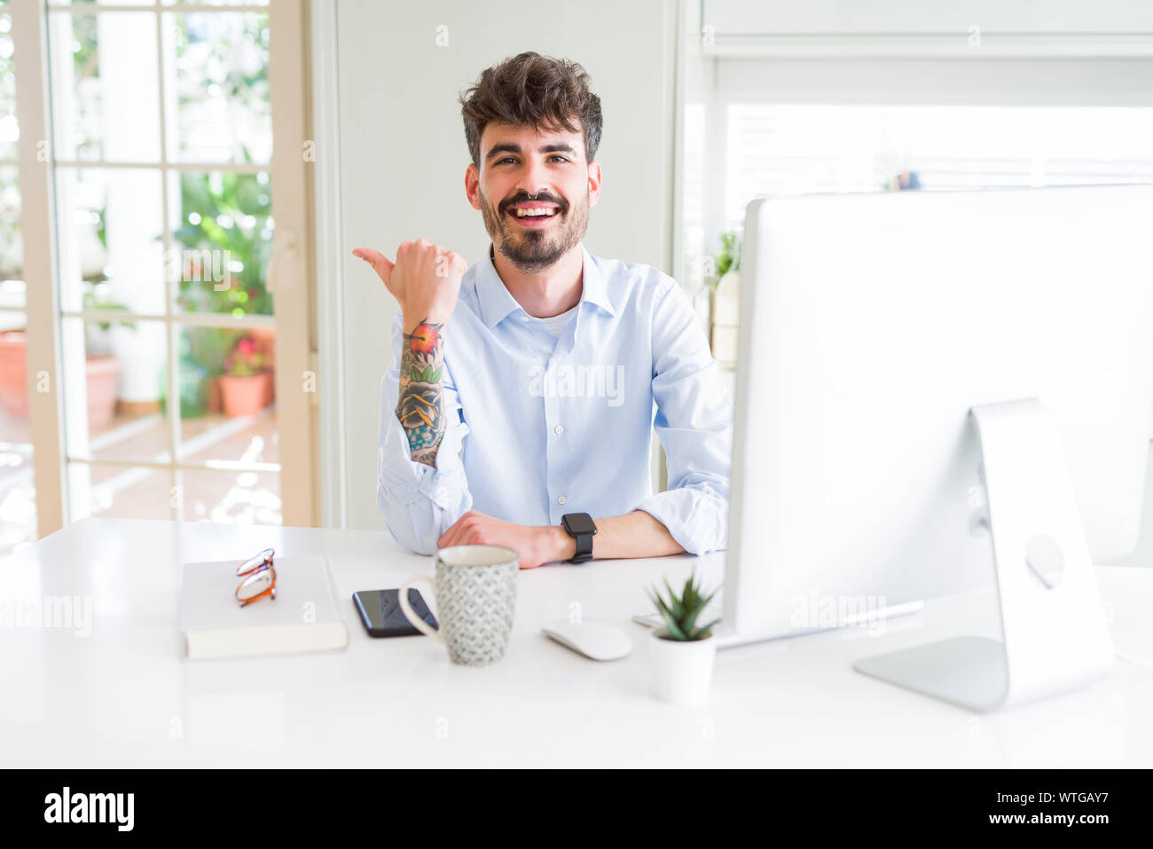 Young business man working using computer smiling with happy face ...