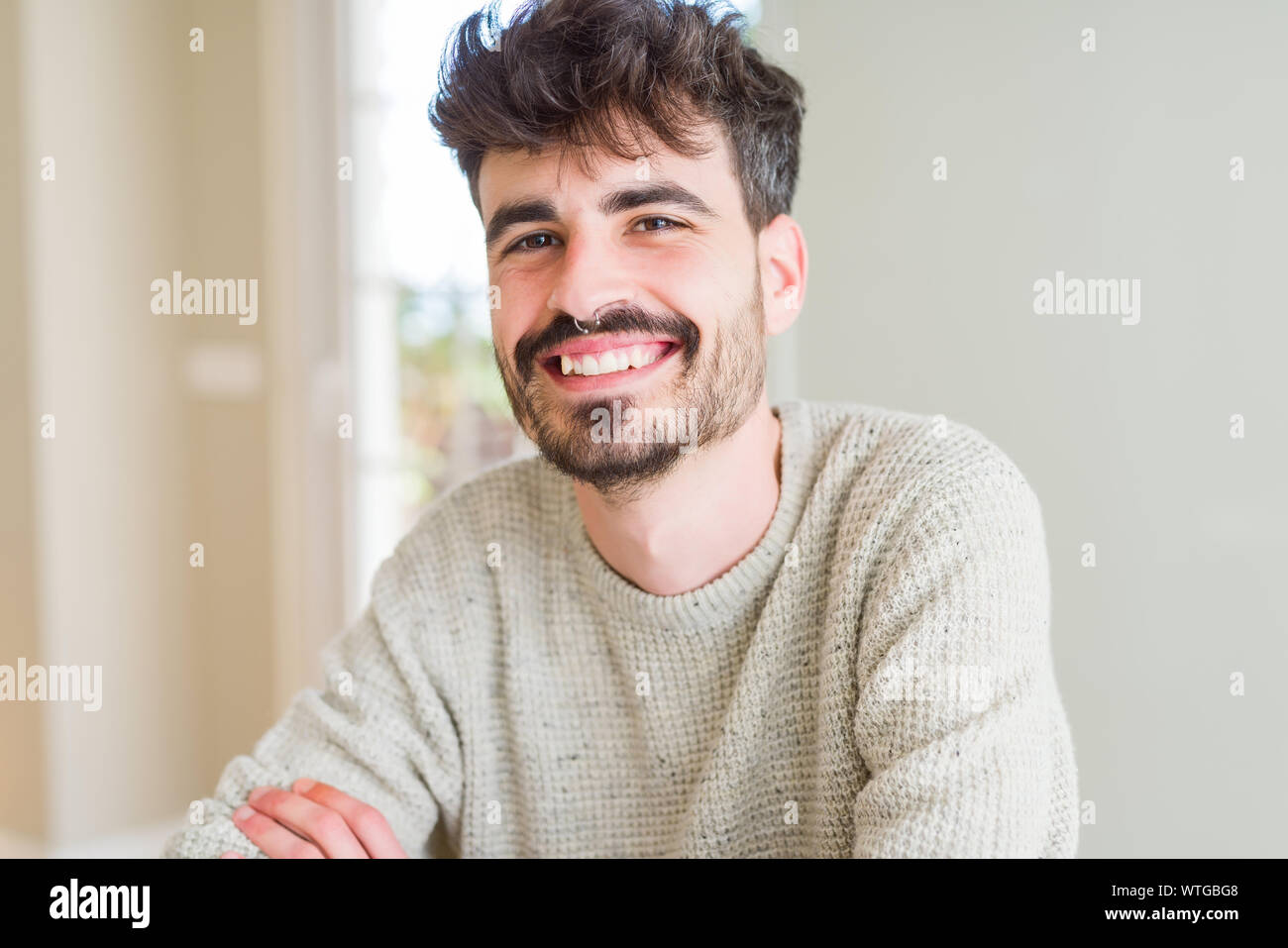 Handsome young man smiling cheerful at the camera with a big smile on ...
