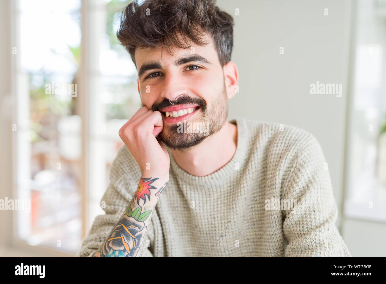 Handsome young man smiling cheerful at the camera with a big smile on ...