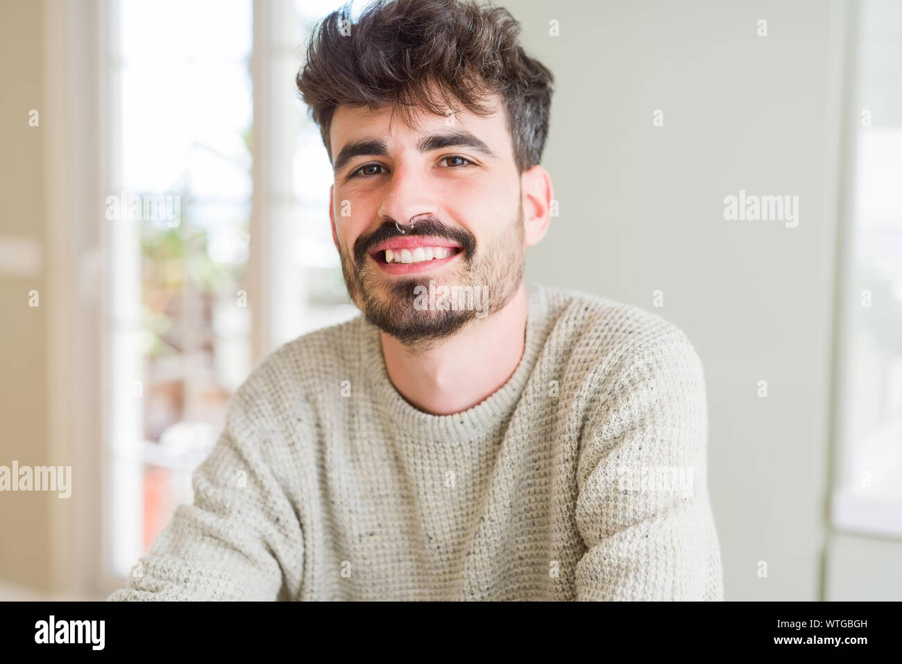Handsome young man smiling cheerful at the camera with a big smile on ...
