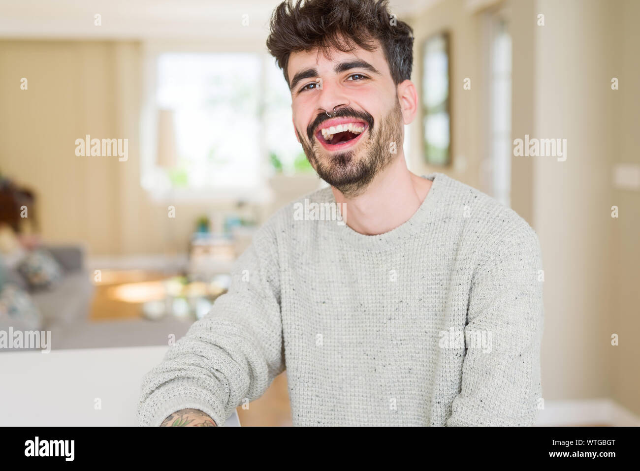 Handsome young man smiling cheerful at the camera with a big smile on ...