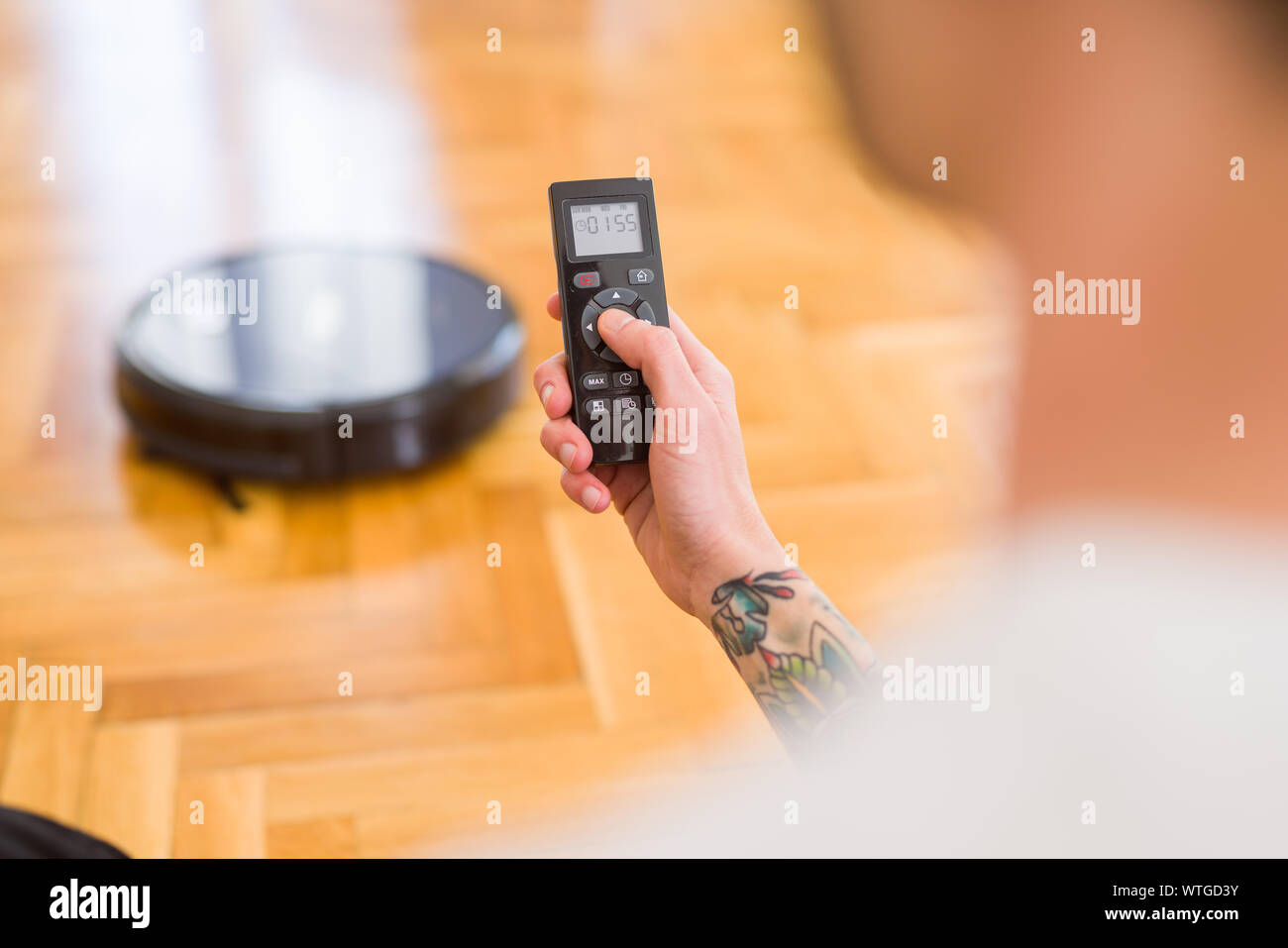 Close up of man hands controling automatic vacuum cleaner using ...
