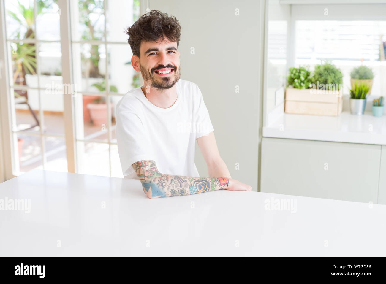 Handsome young man smiling cheerful at the camera with a big smile on ...