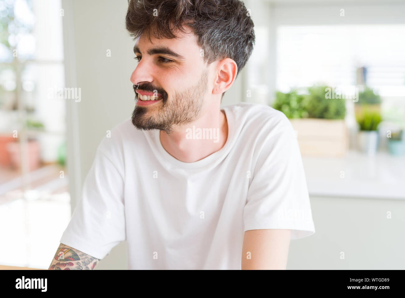 Handsome young man smiling cheerful at the camera with a big smile on ...