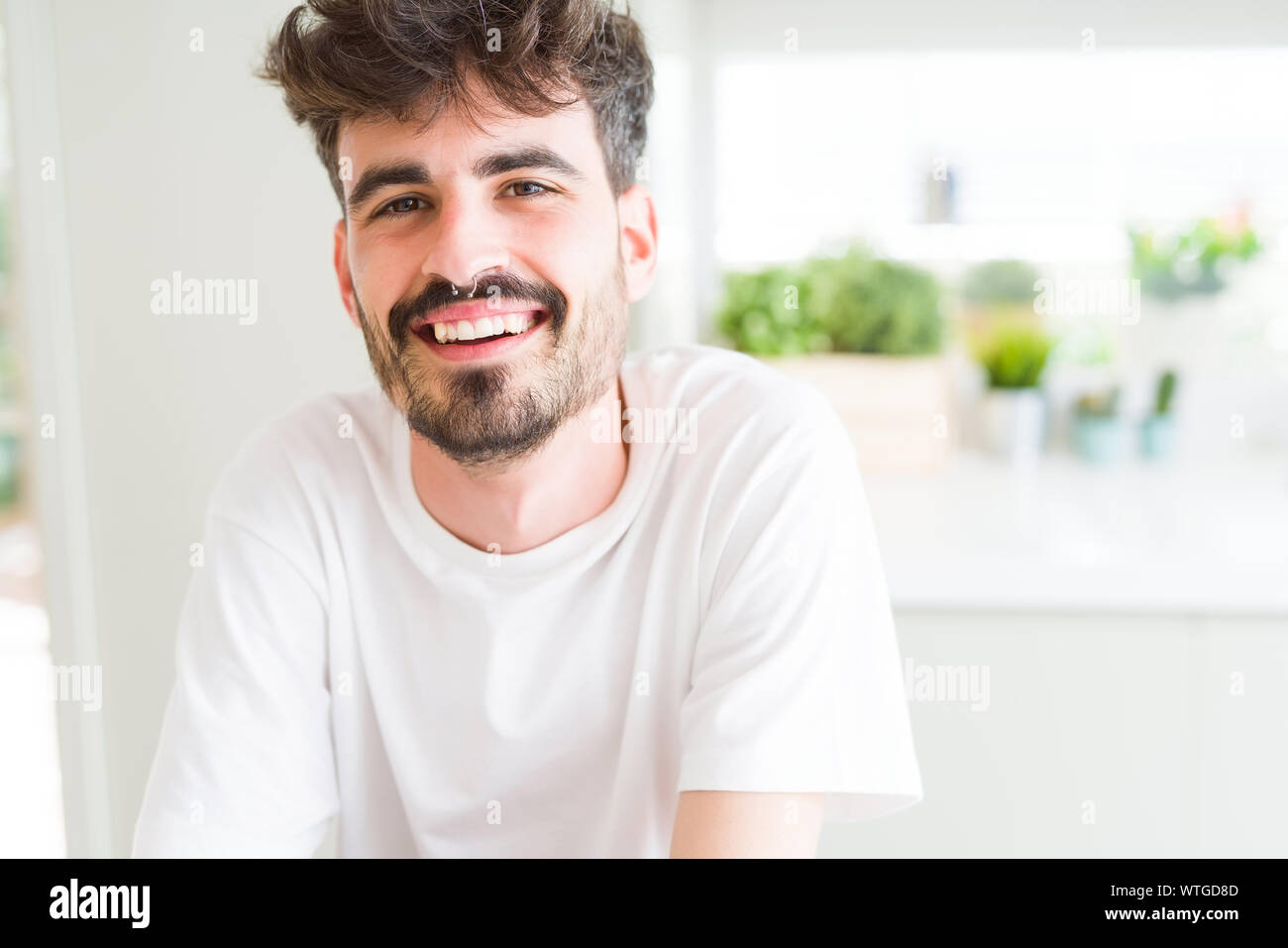 Handsome young man smiling cheerful at the camera with a big smile on ...