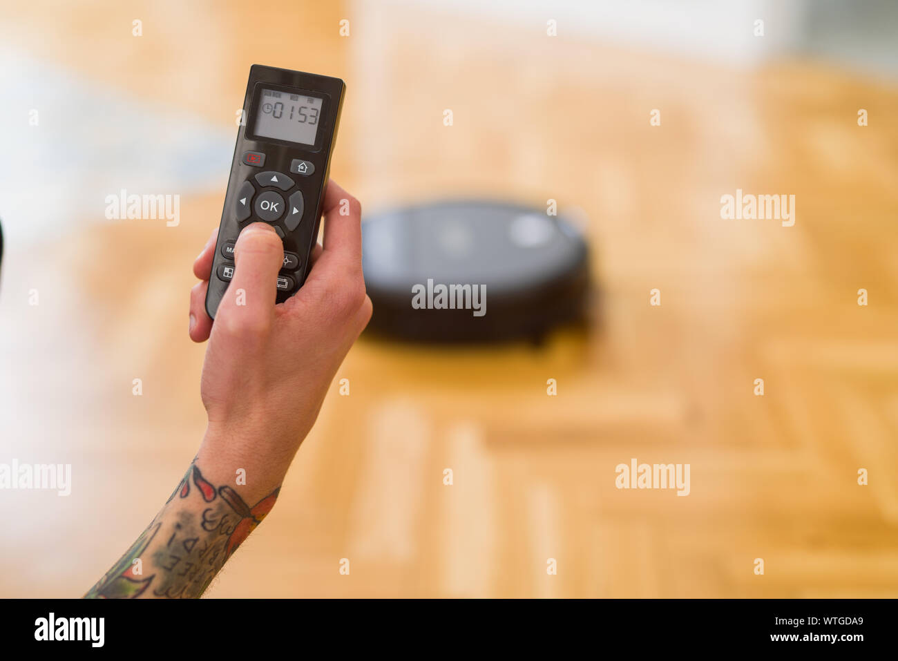 Close up of man hands controling automatic vacuum cleaner using ...