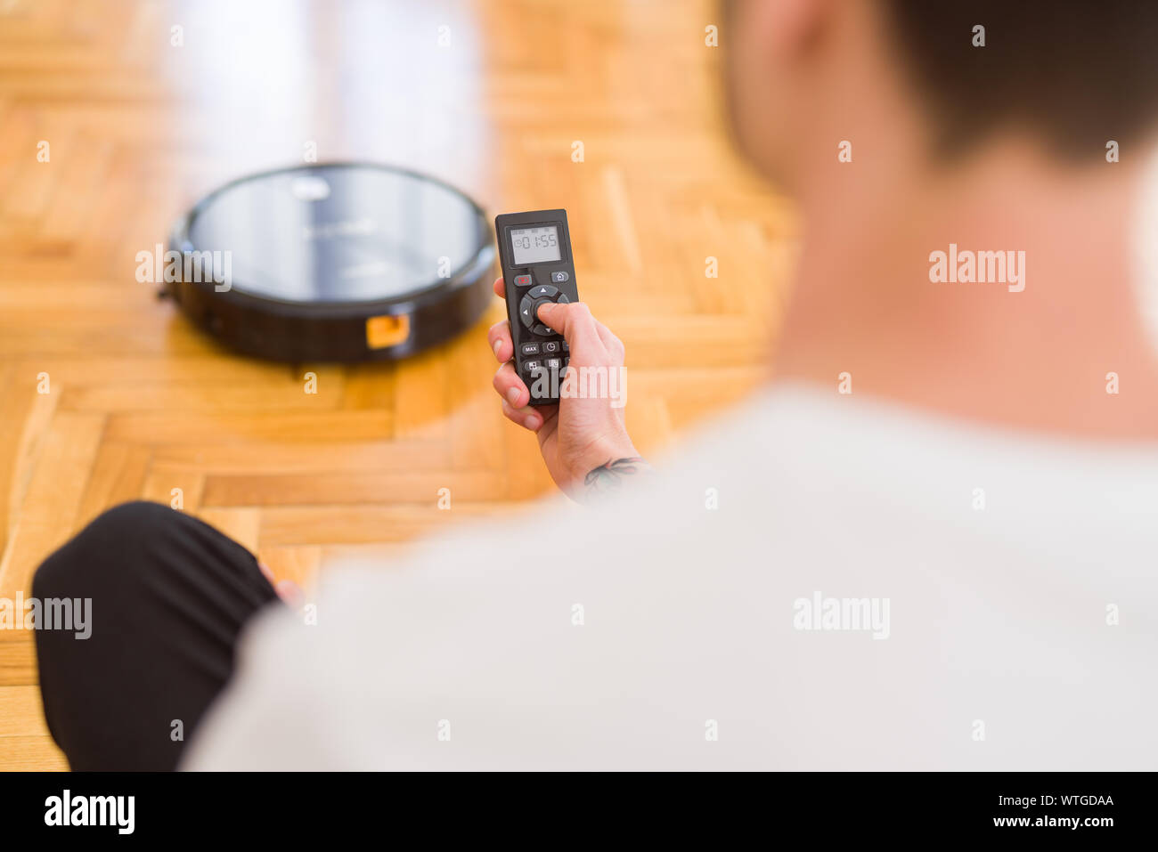 Close up of man hands controling automatic vacuum cleaner using ...