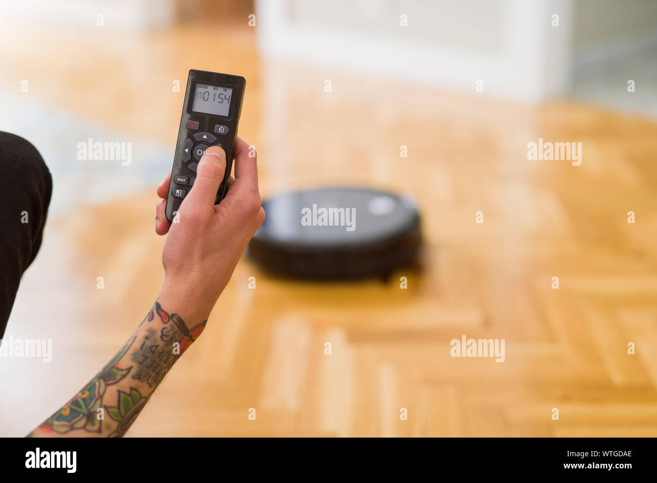Close up of man hands controling automatic vacuum cleaner using ...