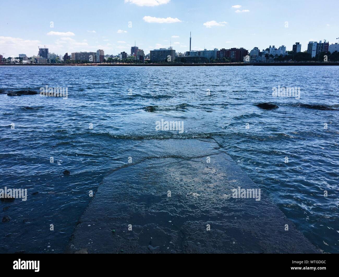 Calm River With Built Structures In Distance Stock Photo - Alamy