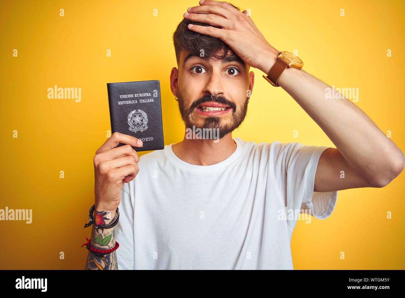 Young man with tattoo wearing Italy Italian passport over isolated ...