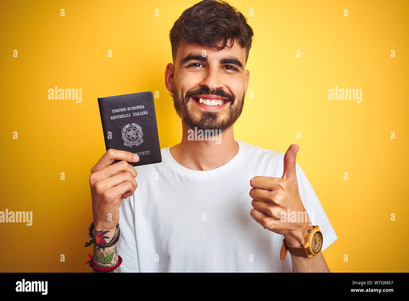 Young man with tattoo wearing Italy Italian passport over isolated ...