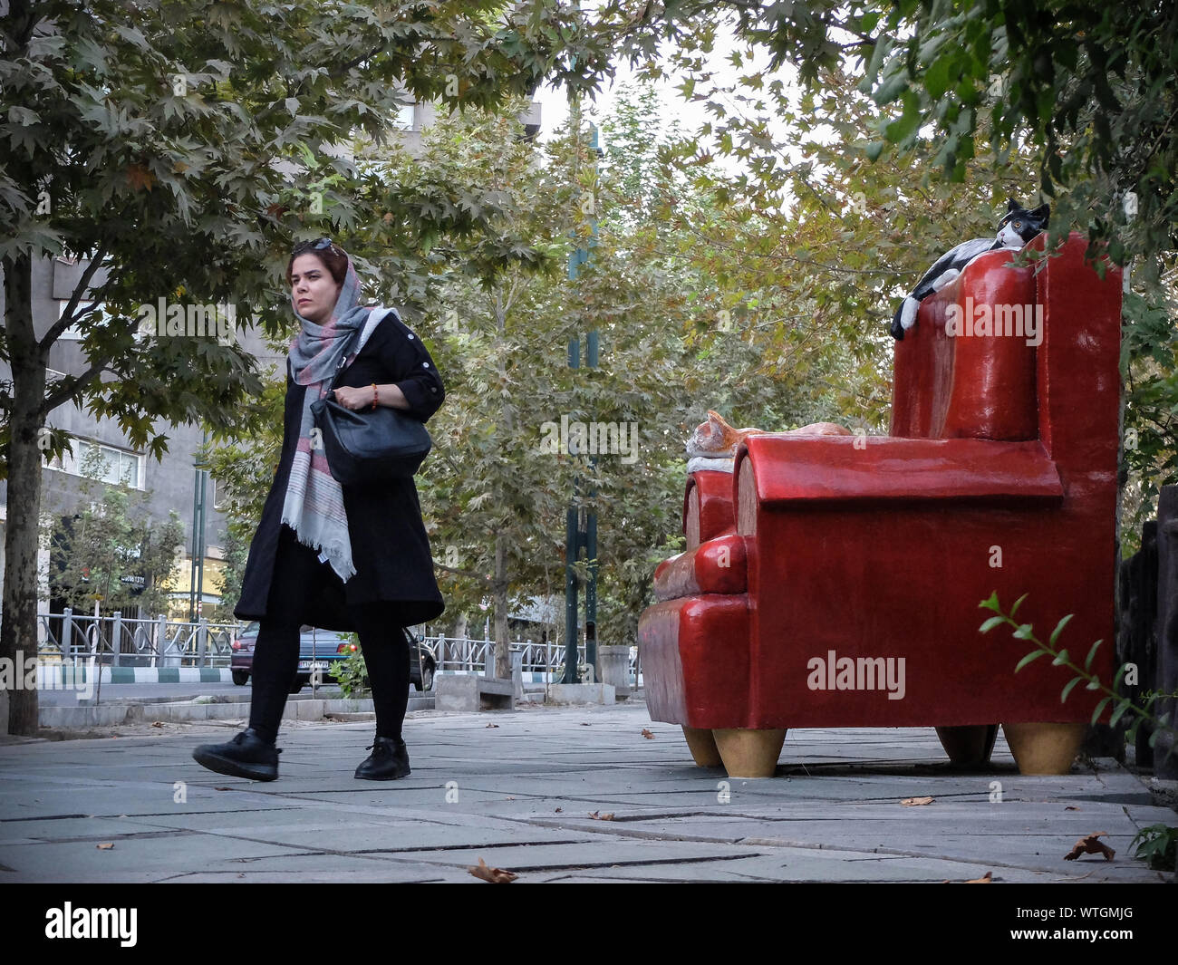 Tehran, Iran. 12th Sep, 2019. A woman walks on a sidewalk on Valiasr ...