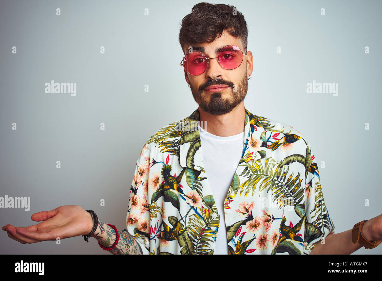 Man with tattoo on vacation wearing summer shirt sunglasses over ...