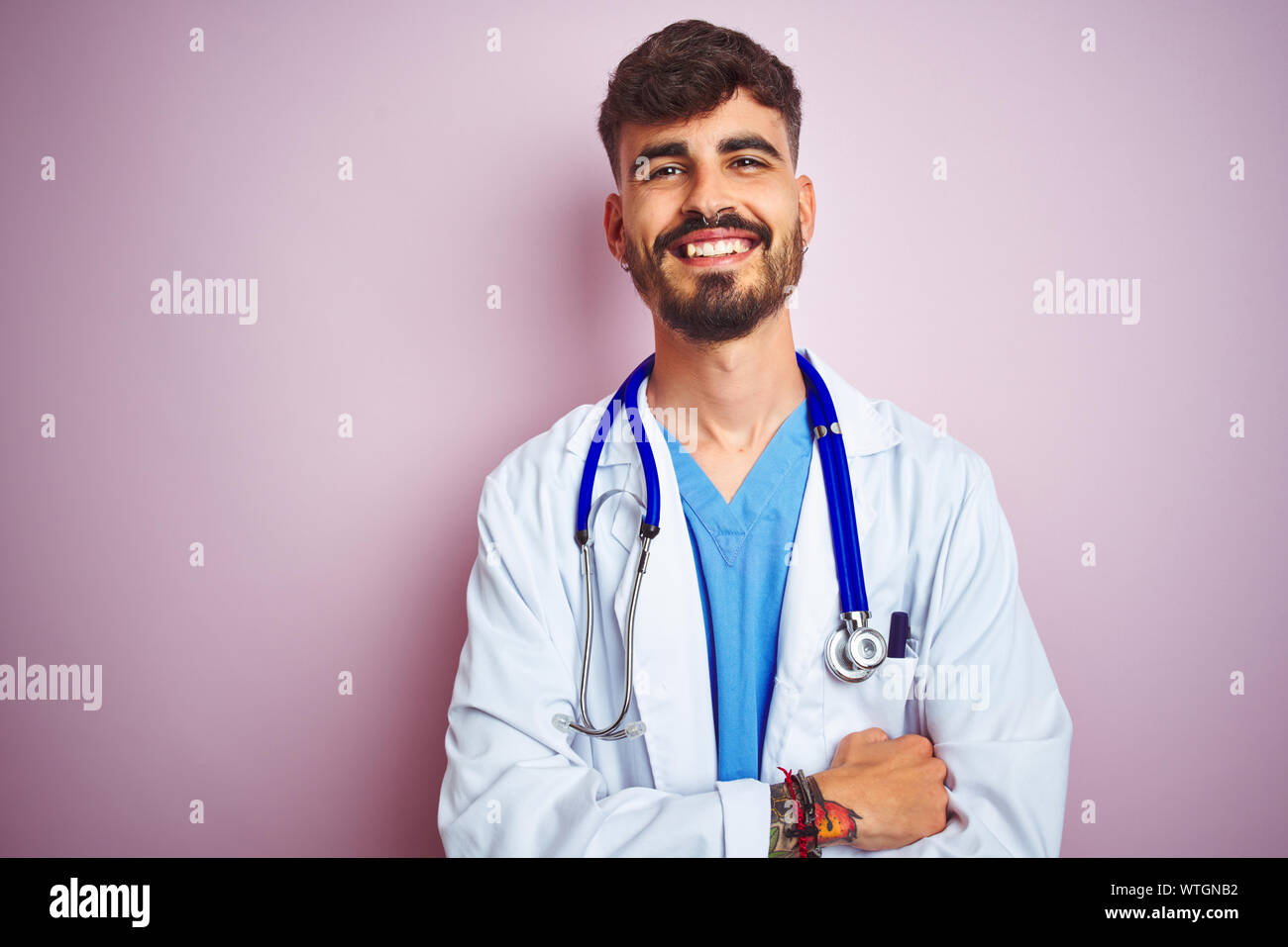 Young doctor man with tattoo wearing stethocope standing over isolated ...