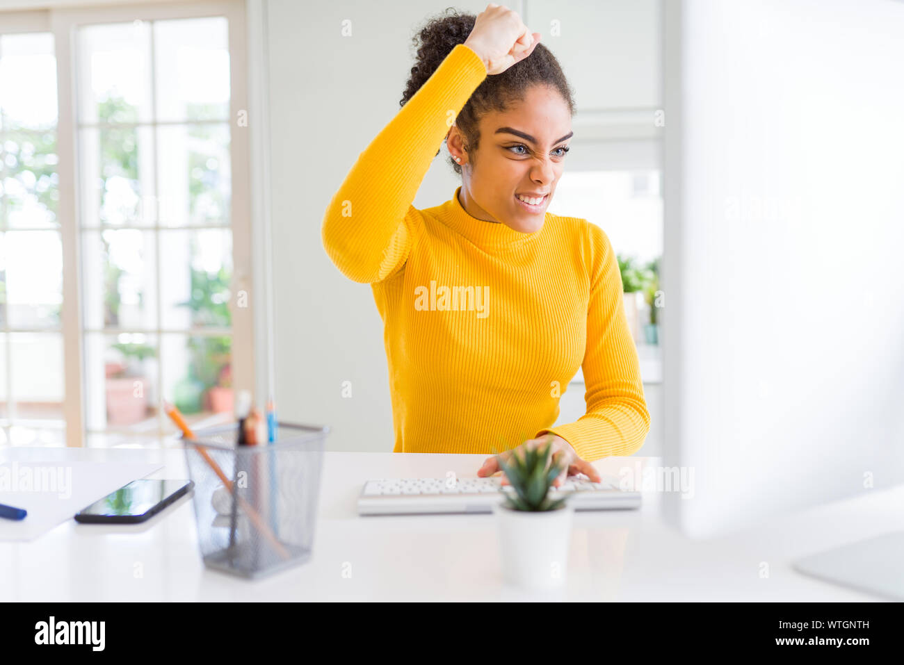 Young african american girl working using computer annoyed and ...