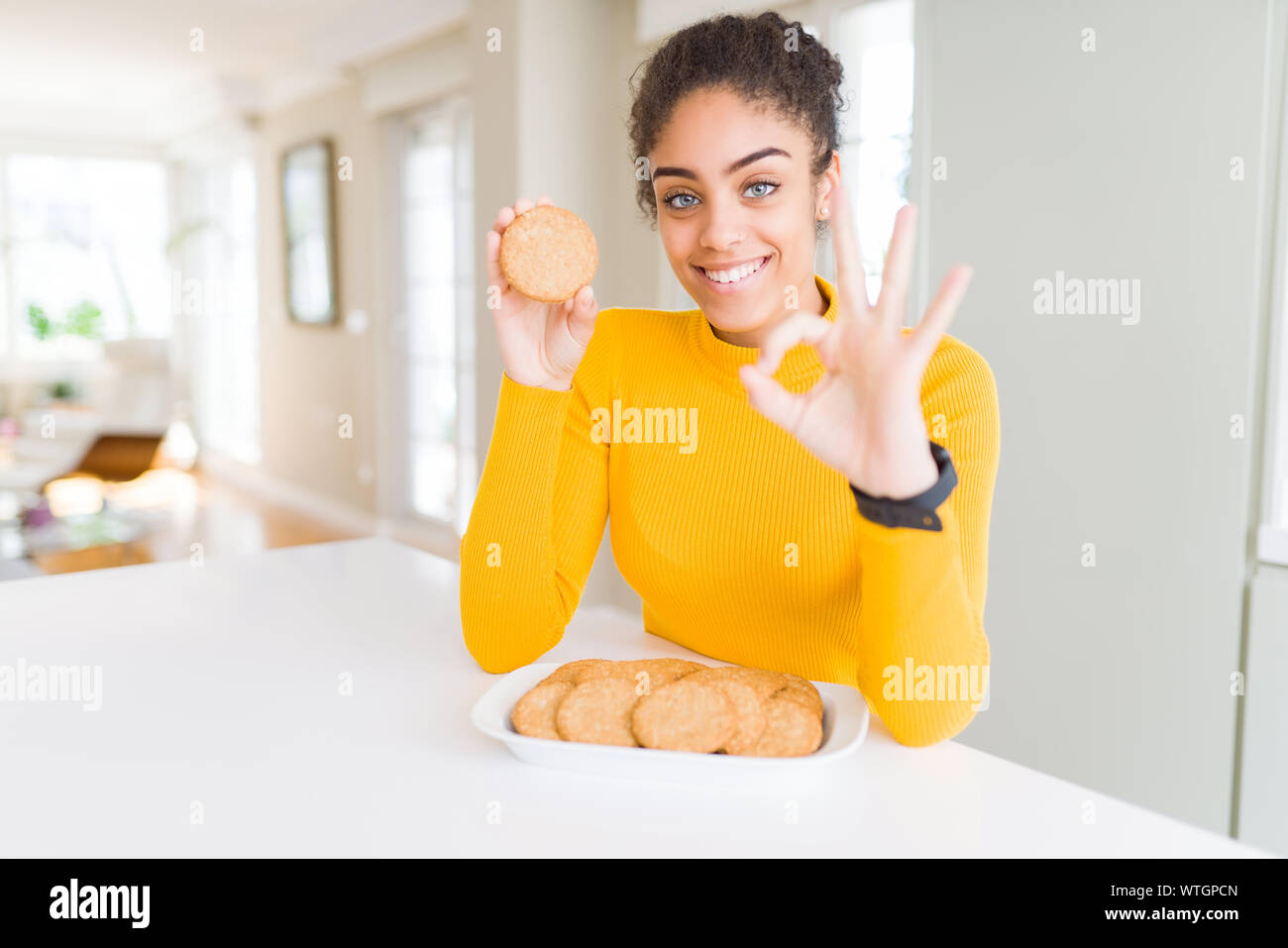 Young african american girl eating healthy whole grain biscuits doing ...