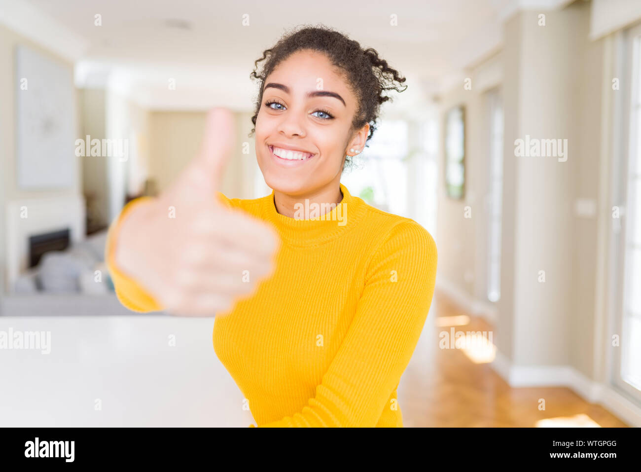 Beautiful young african american woman with afro hair doing happy ...