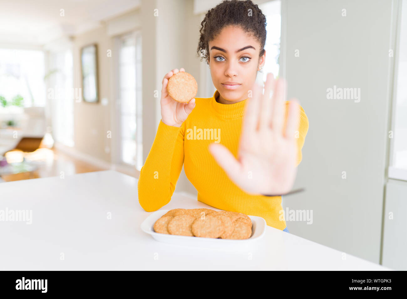 Young african american girl eating healthy whole grain biscuits with ...
