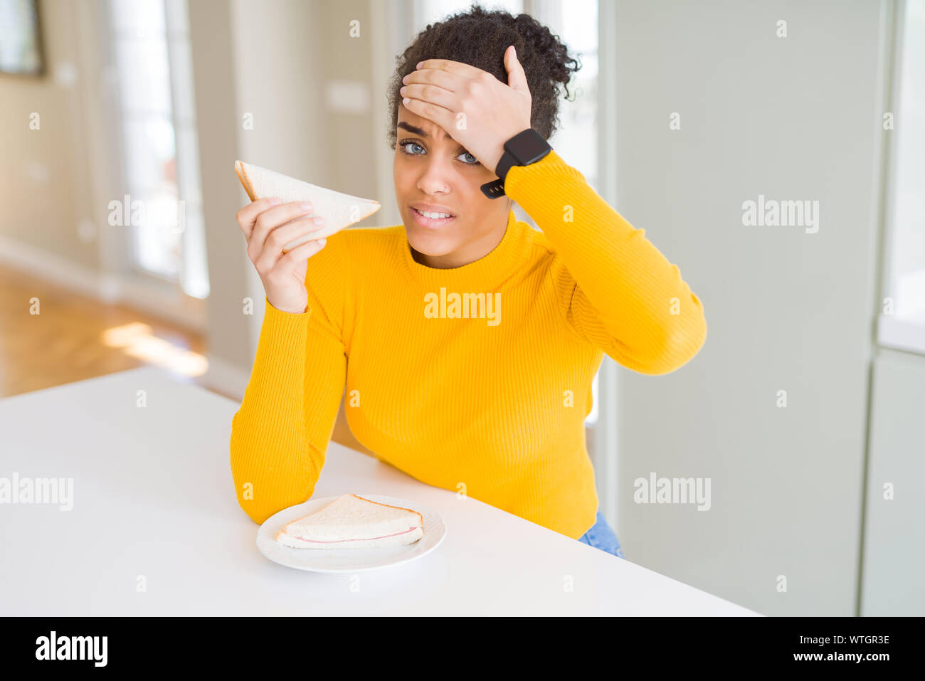 Young african american woman eating a sandwich as healthy snack ...