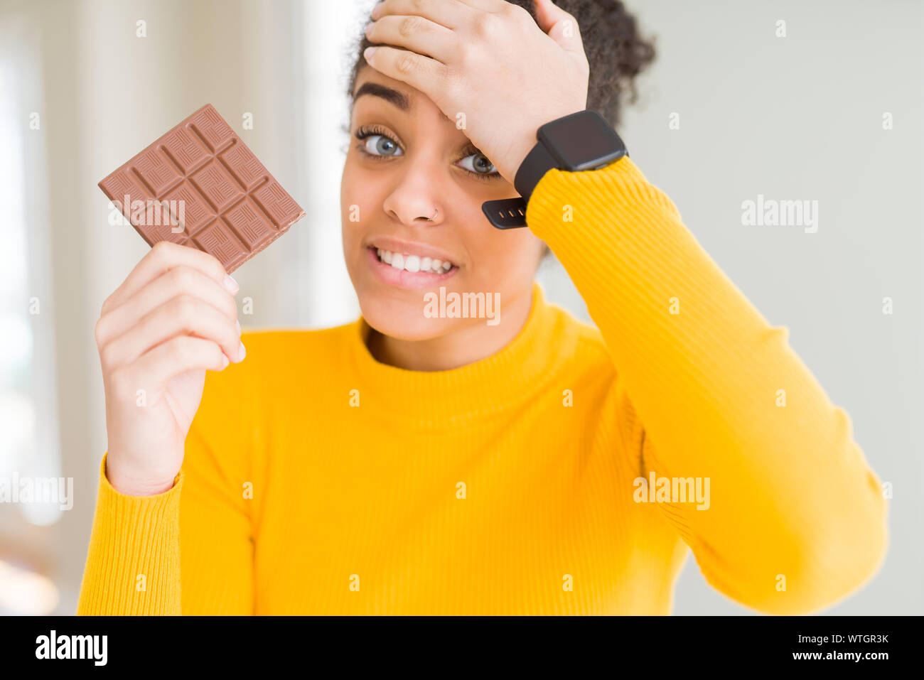Young african american girl eating dark chocolate bar as a sweet snack ...