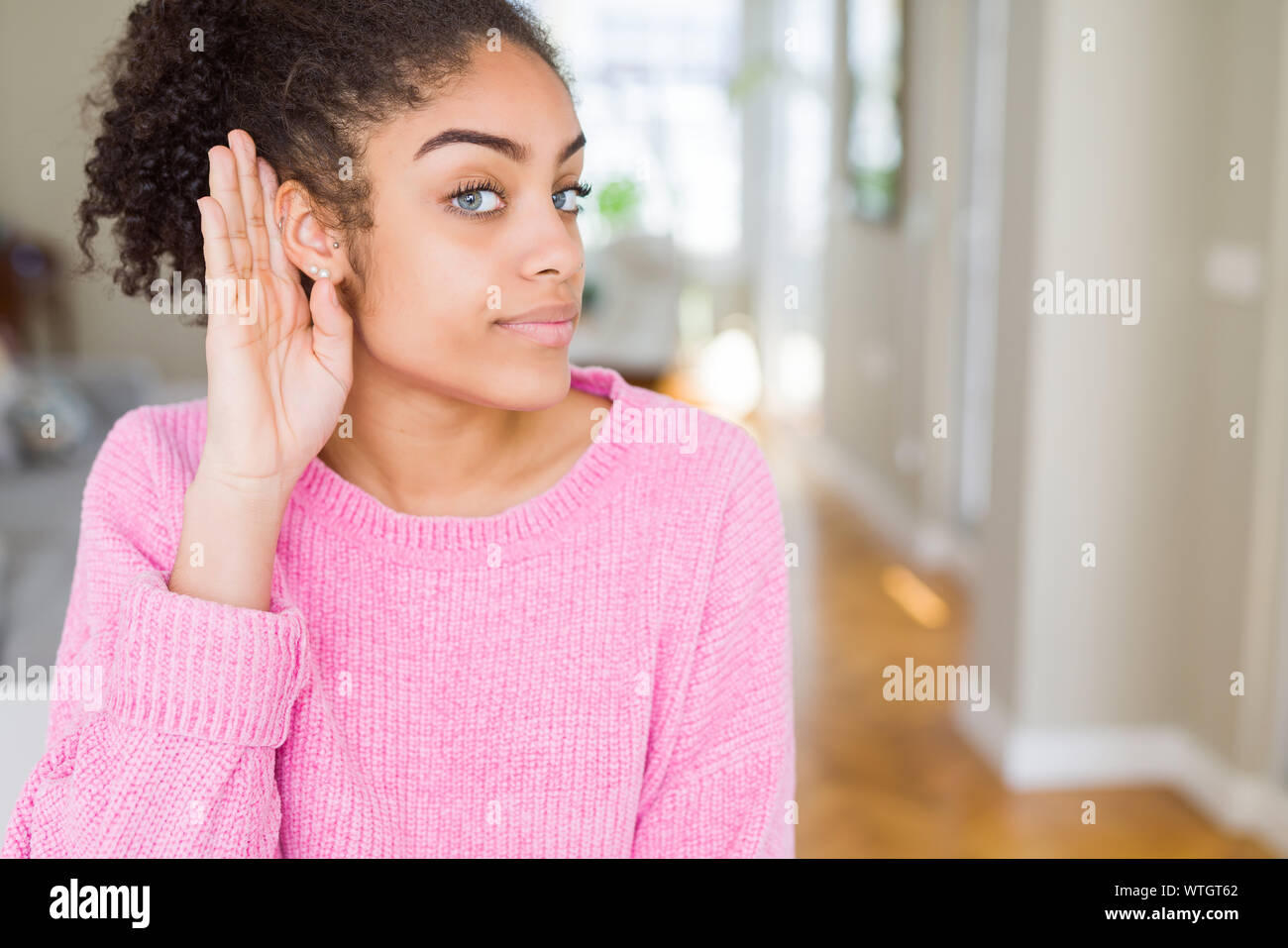 Beautiful young african american woman with afro hair smiling with hand ...