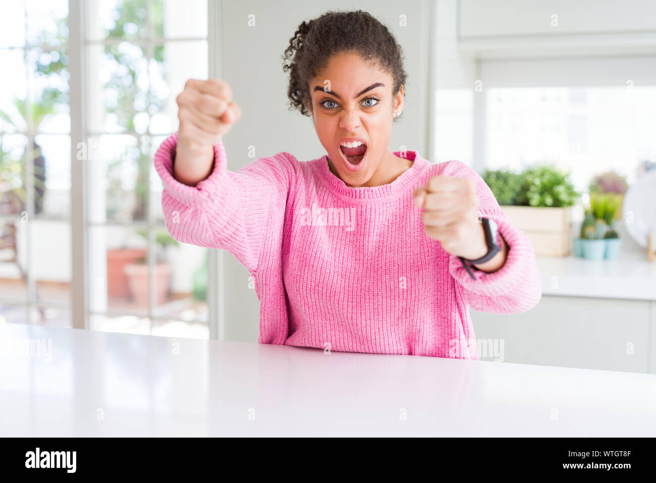 Beautiful african american woman with afro hair wearing casual pink ...